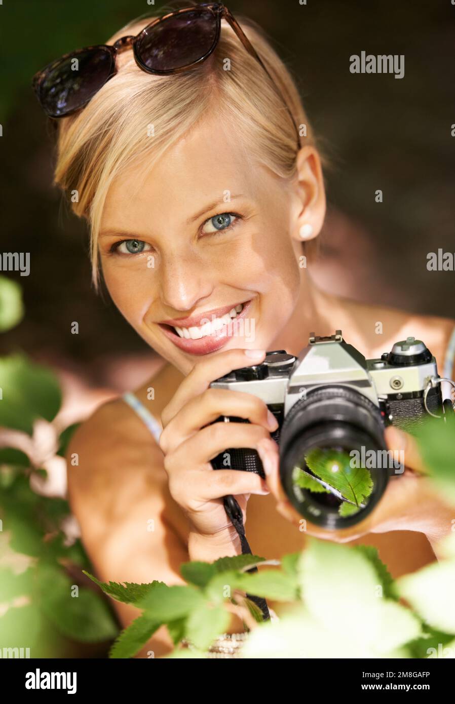 Smile. Pretty young photographer in the woods getting ready to take a ...