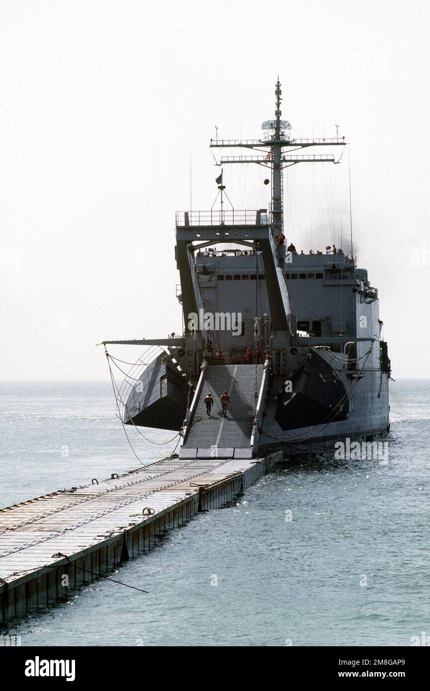 The bow door of a tank landing ship opens onto a pontoon causeway as ...