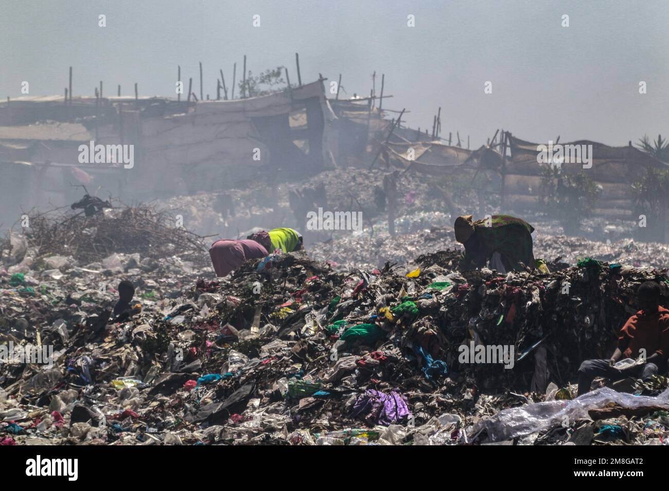 Waste pickers recover waste for recycling amidst heavy smoke from ...