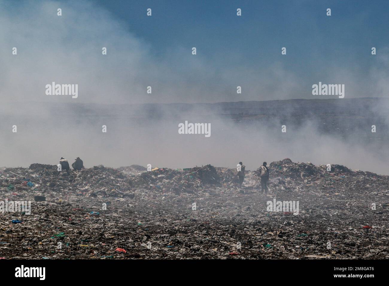 Waste pickers recover waste for recycling amidst heavy smoke from ...