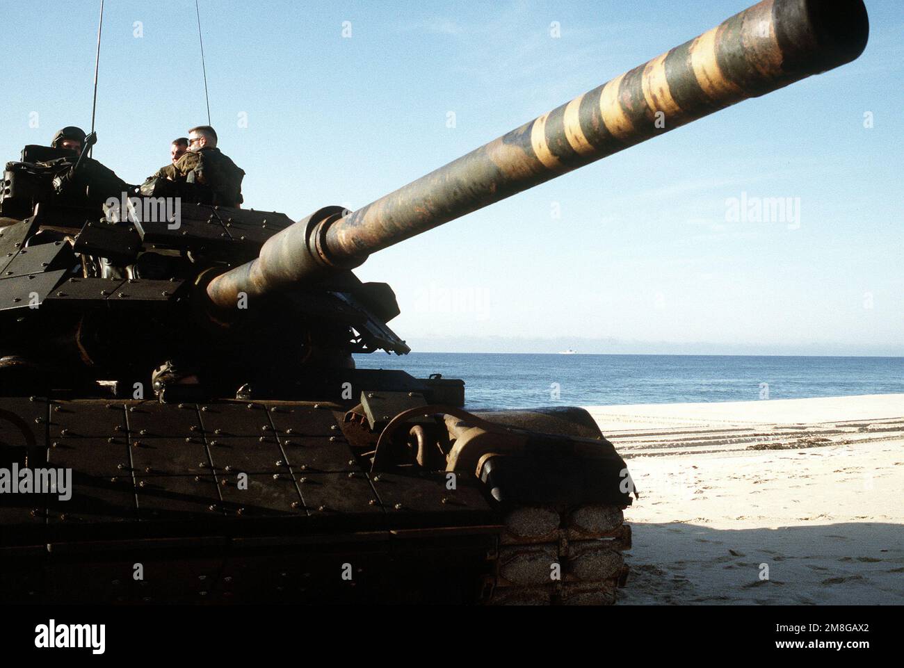 An M-60 main battle tank is driven off a utility landing craft from the ...