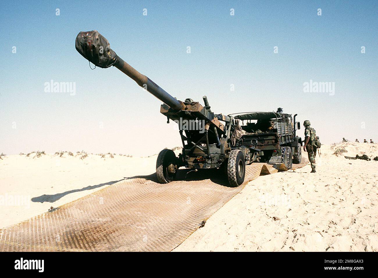 A tactical truck tows an M-198 155mm howitzer from a utility landing ...