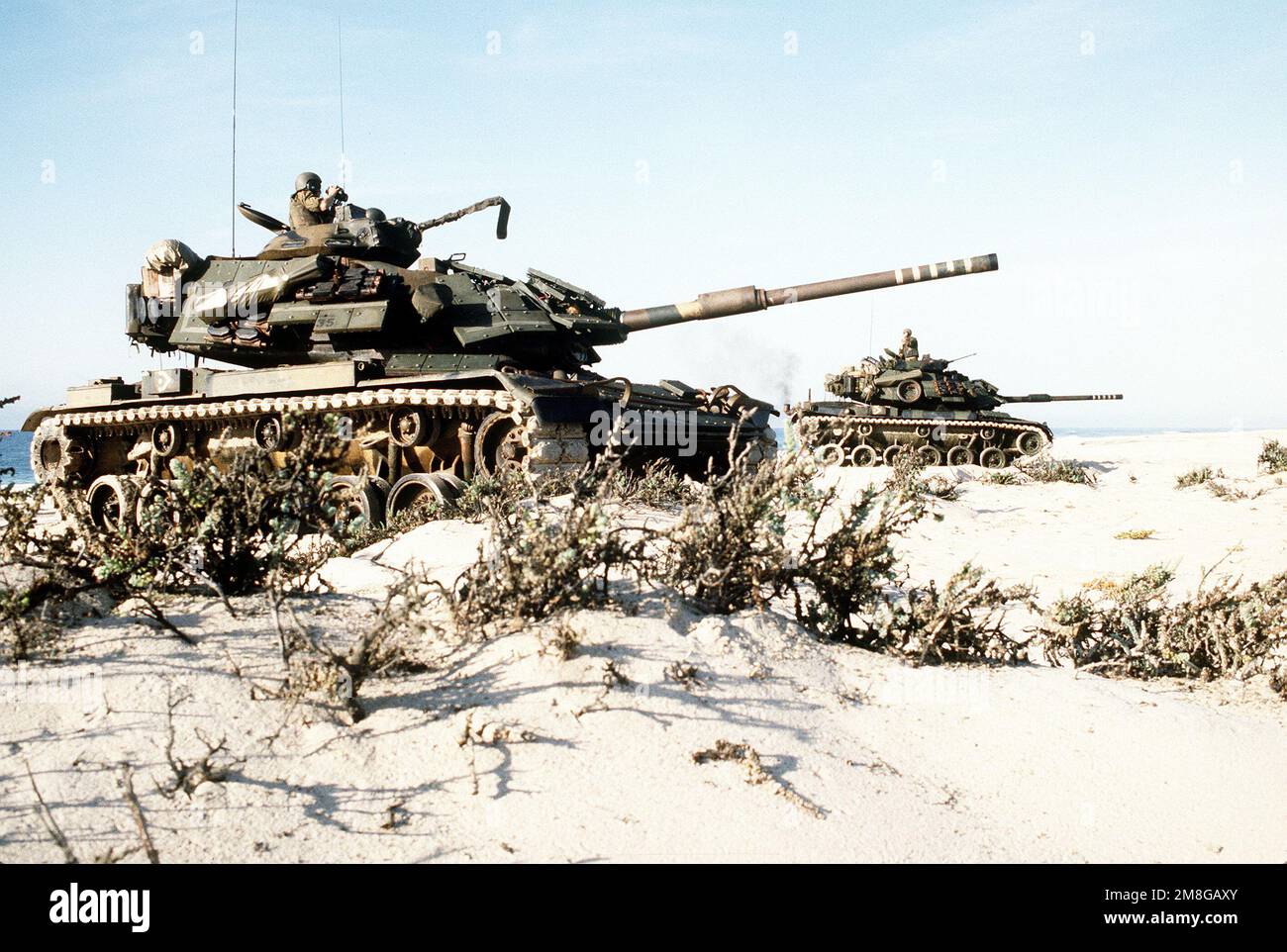 M-60 main battle tanks are driven off a utility landing craft from the ...