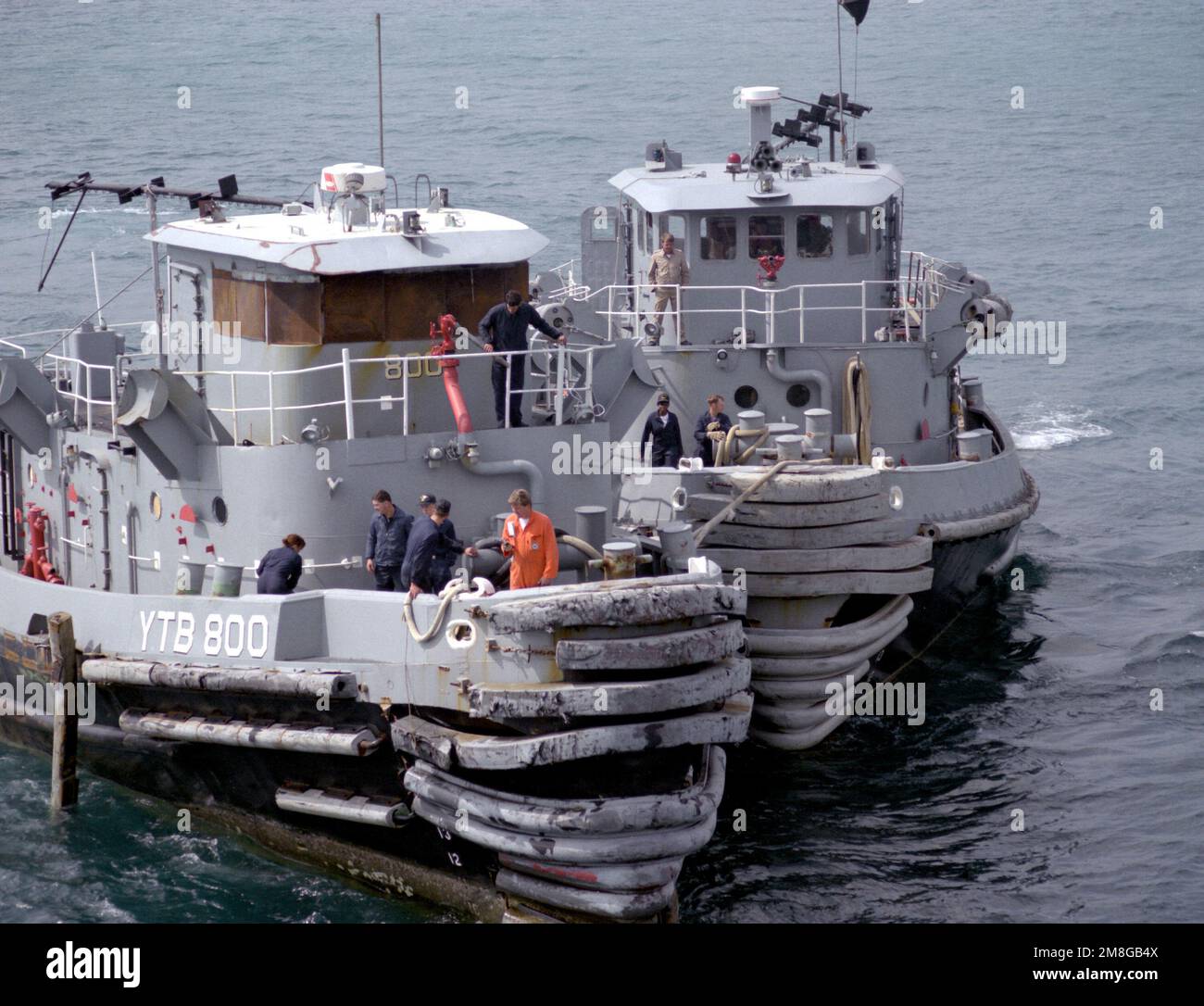 The large harbor tug EUFAULA (YTB-800) and another tug are positioned ...