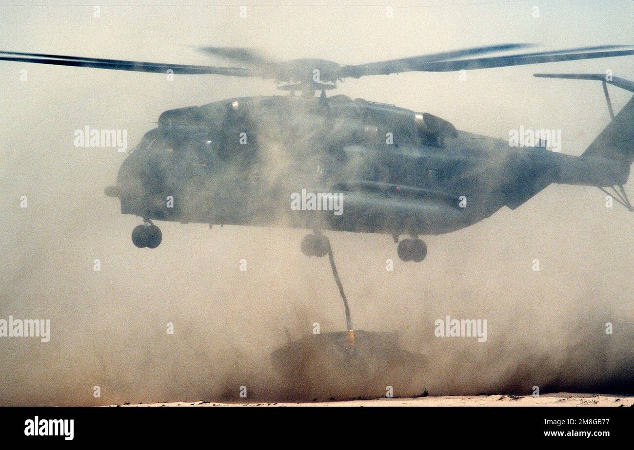 A Marine CH-53 Sea Stallion helicopter lowers an M998 High-Mobility ...