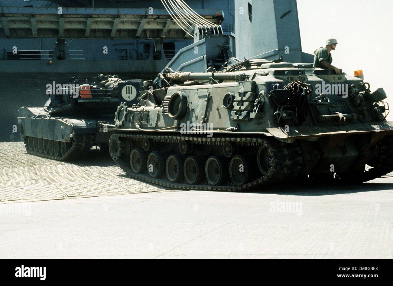 An M-1A1 Abrams main battle tank, background, and an M-88A1 armored ...