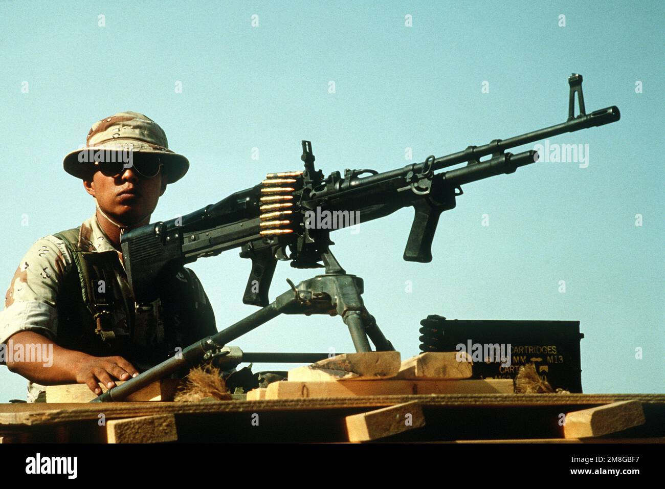 A machine gunner mans a 7.62mm M-60 machine gun as he stands guard ...