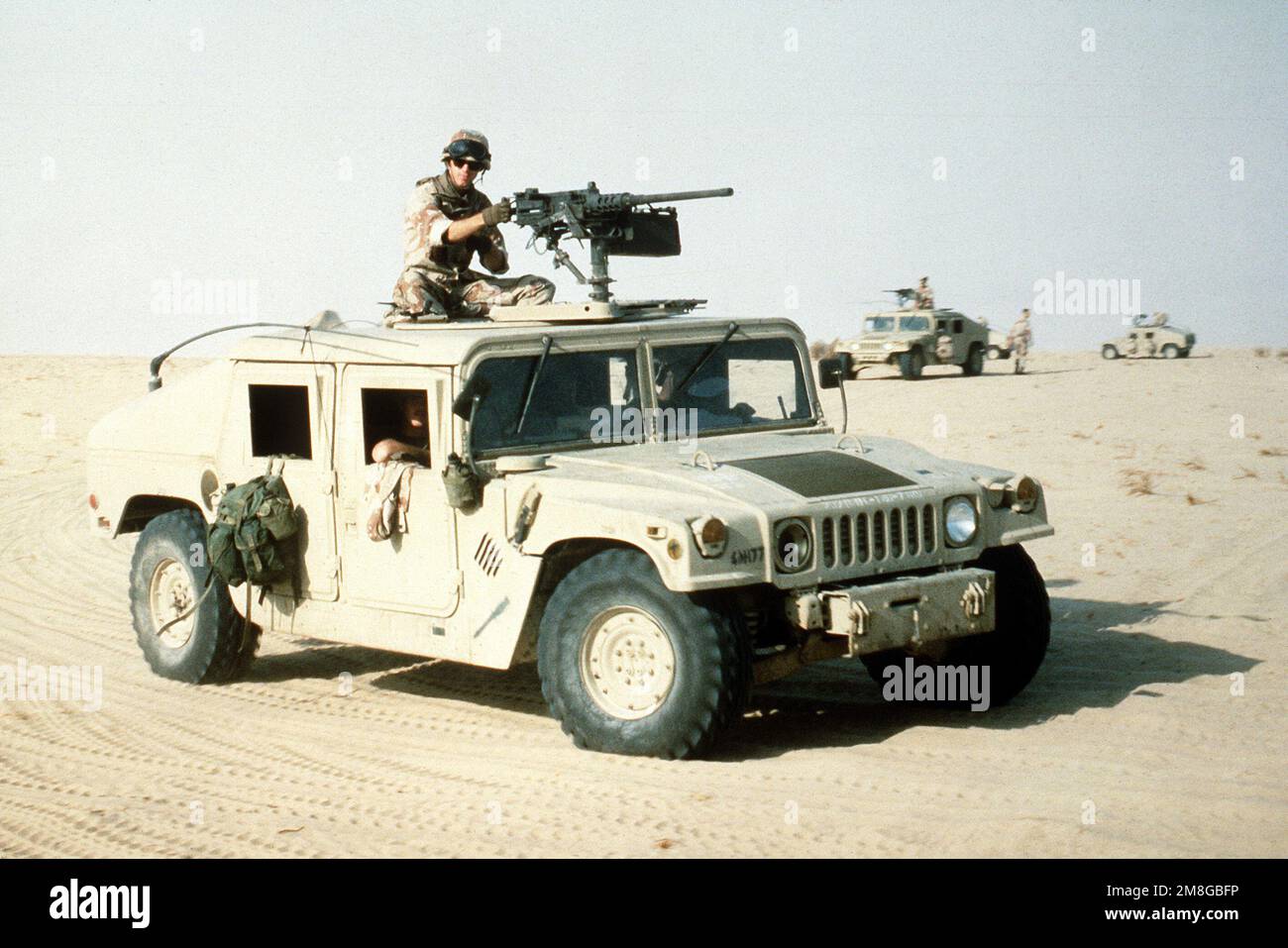 A machine gunner mans an M-2 .50-caliber machine gun positioned atop an M1038 High-Mobility ...
