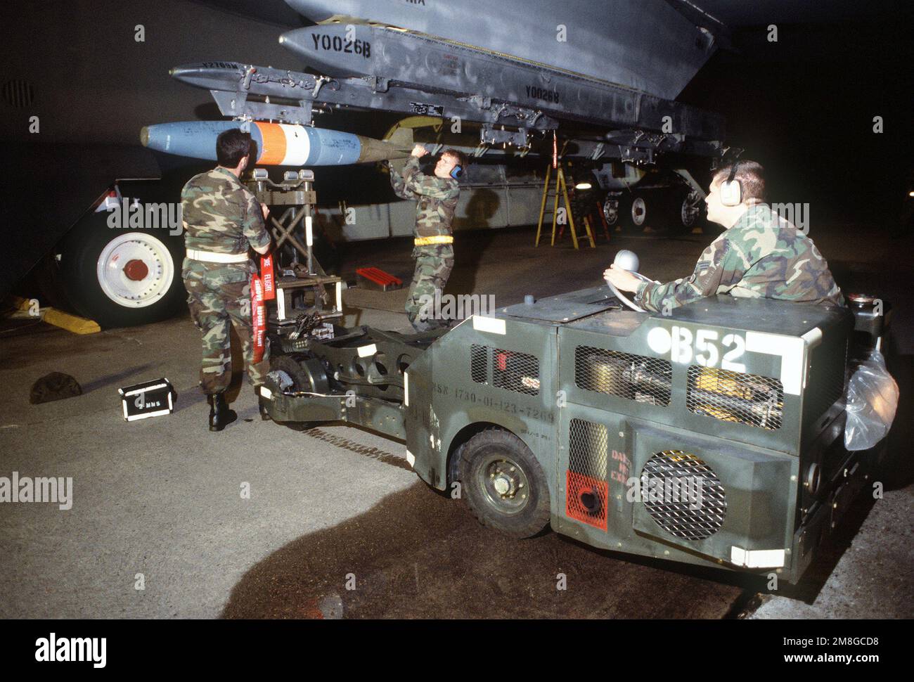 Members of the 2nd Munitions Maintenance Squadron use an MJ-1B bomb loader to load a BDU-50 low ...