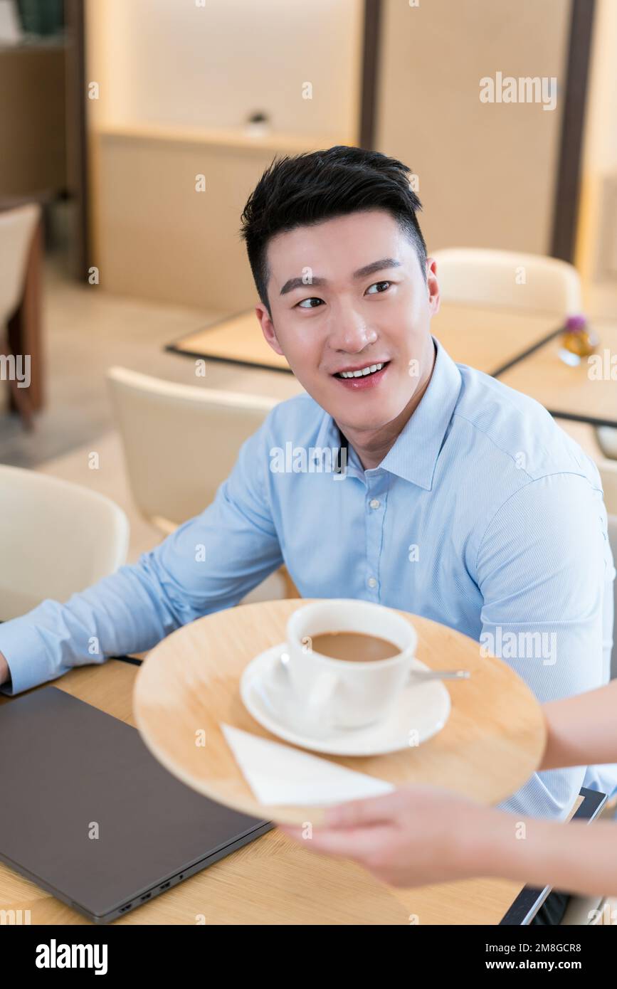 The waiter brought the customer coffee Stock Photo - Alamy