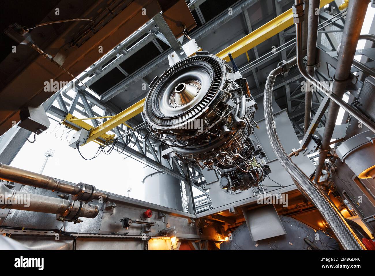 The engine of a gas turbine compressor hangs on a crane during ...