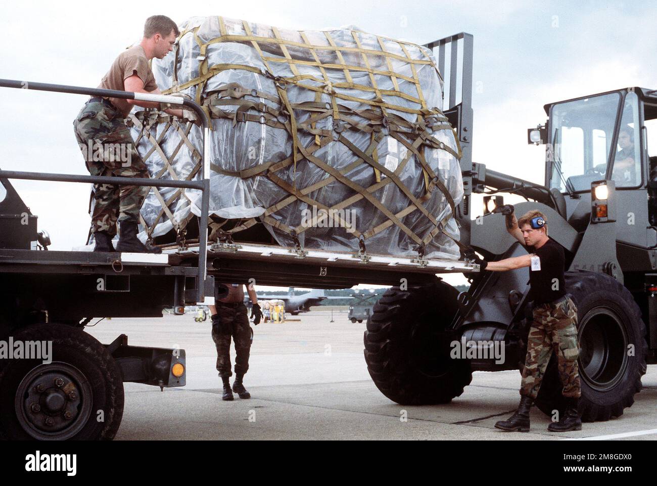 Members of the 314th Aerial Port Squadron move a pallet of cargo from a ...