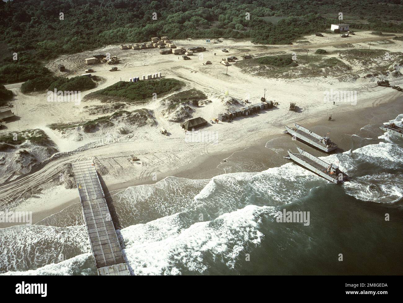 U.S. Army Utility landing craft stand ready to receive equipment as ...