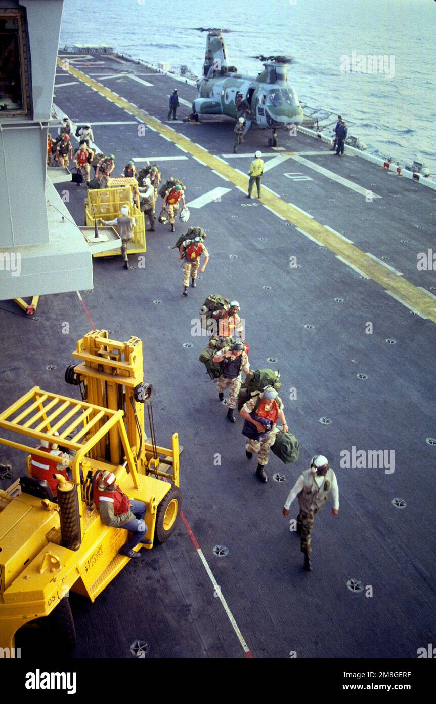 Marines cross the flight deck of the amphibious assault ship USS INCHON ...