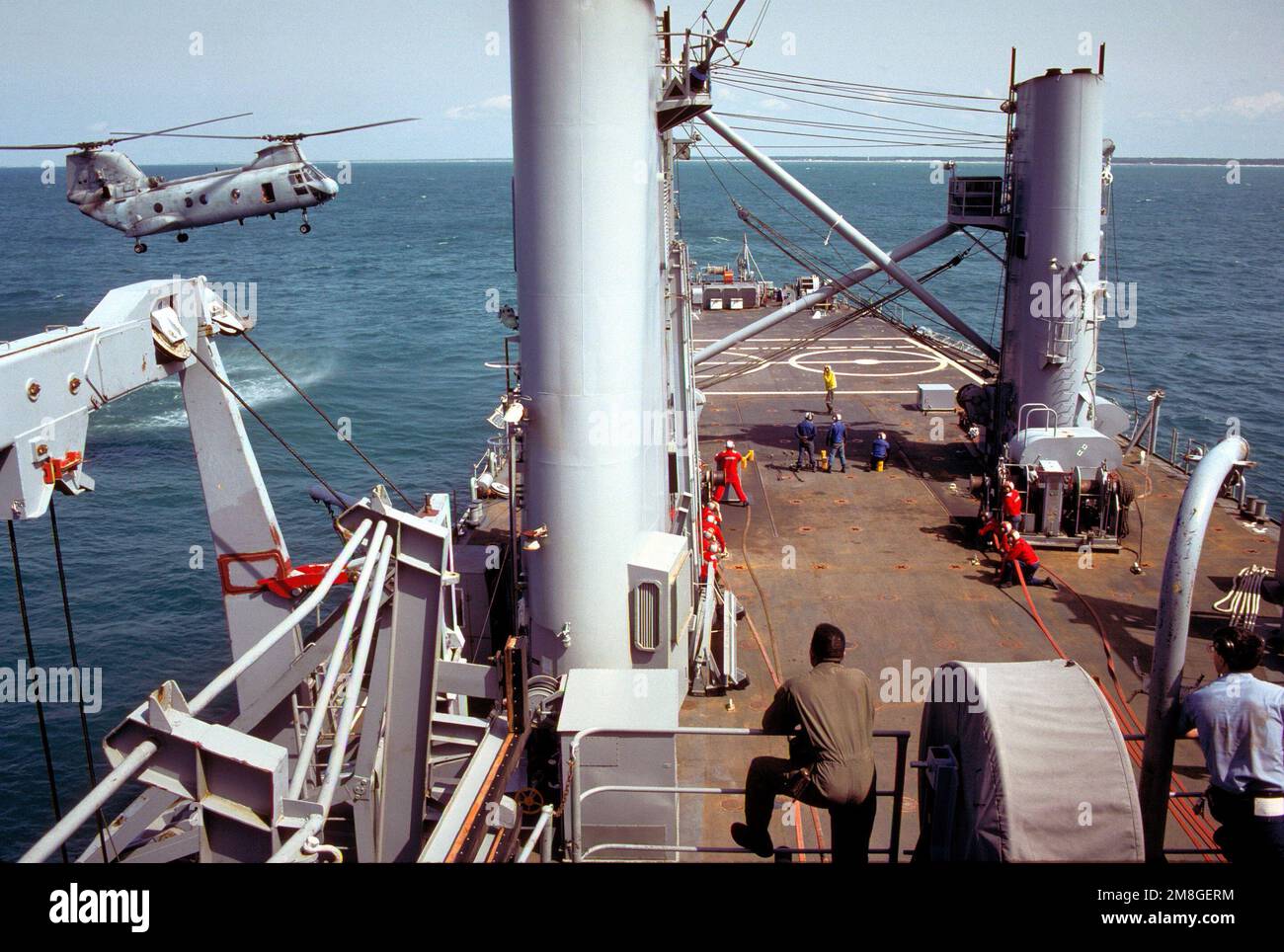 Flight deck crew and firefighters stand ready as a Marine CH-46E Sea ...