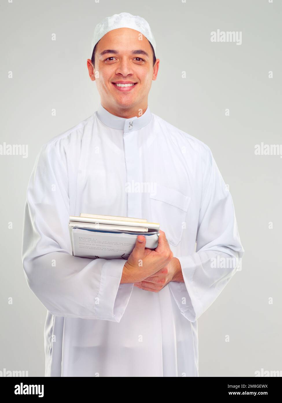 Islamic man, smile portrait and books for learning standing in white ...