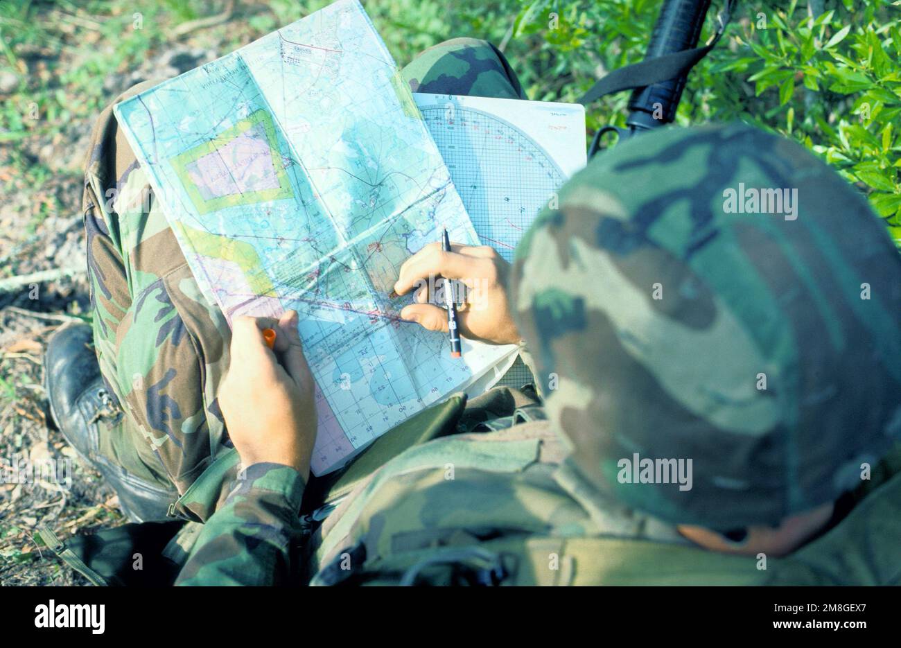 A member of the 2nd Marine Division verifies his map coordinates after ...