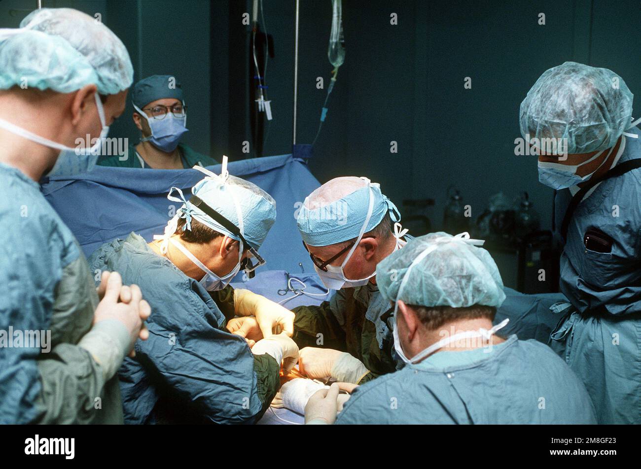 A surgical team headed by LT. CMDR. Randall Culp, with magnifying ...