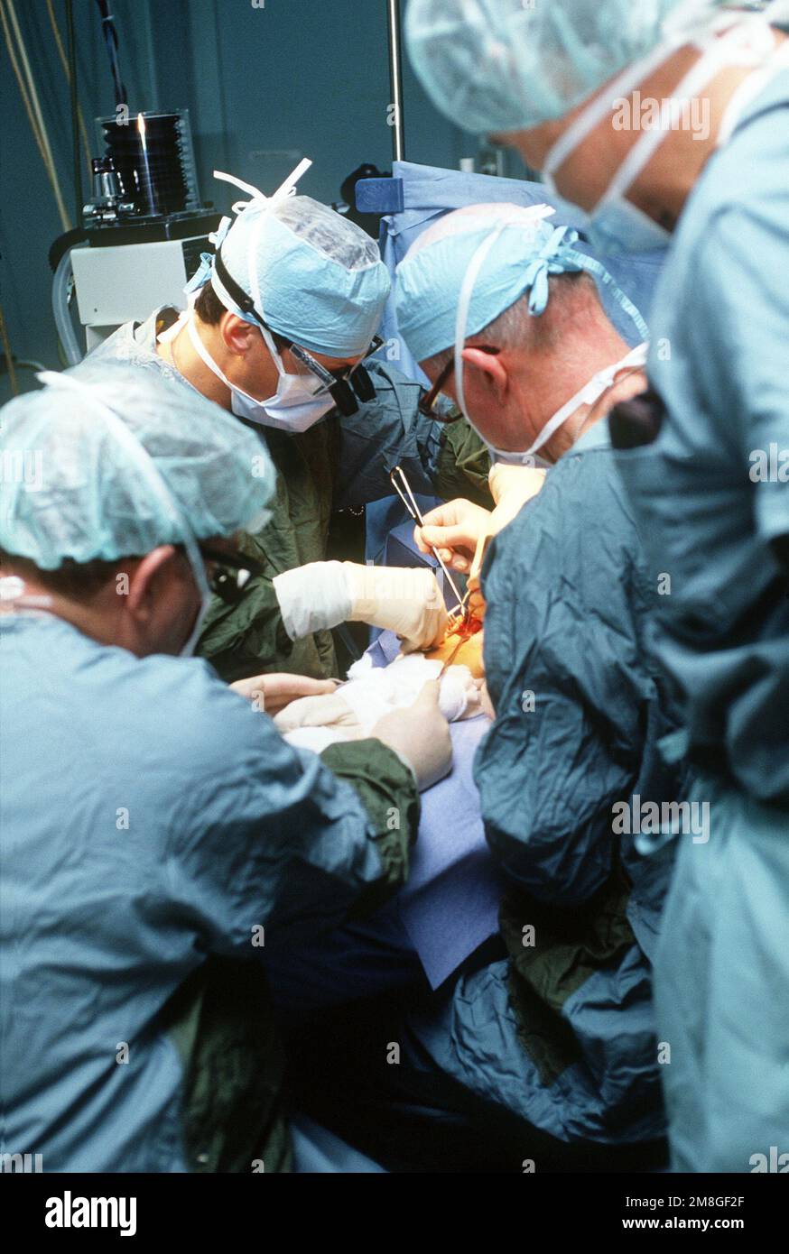 A surgical team headed by LT. CMDR. Randall Culp, with magnifying ...