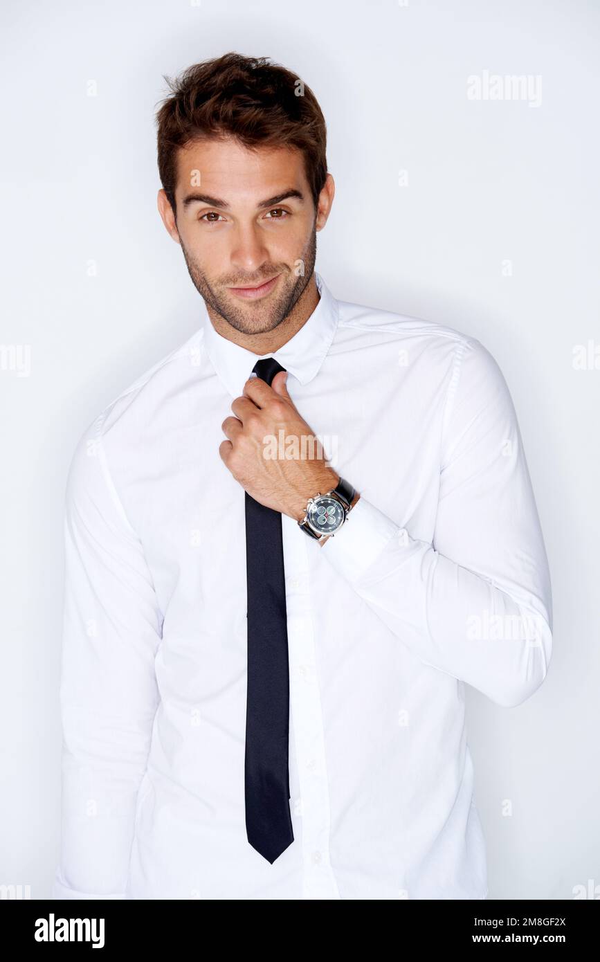 Stylish modern man. Handsome young guy adjusting his tie against a ...