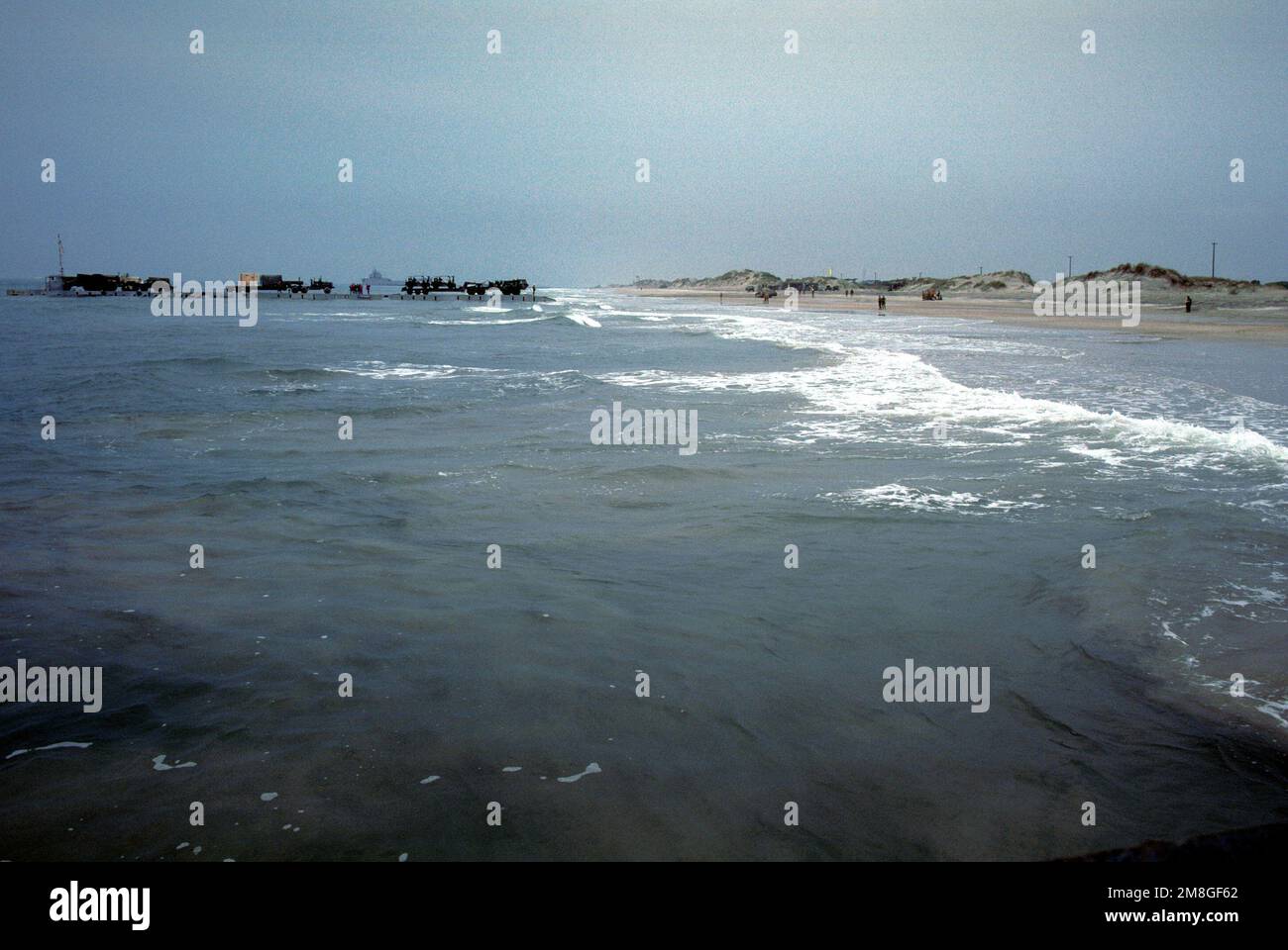 Military trucks, fork lifts and trailers, loaded onto a floating ...