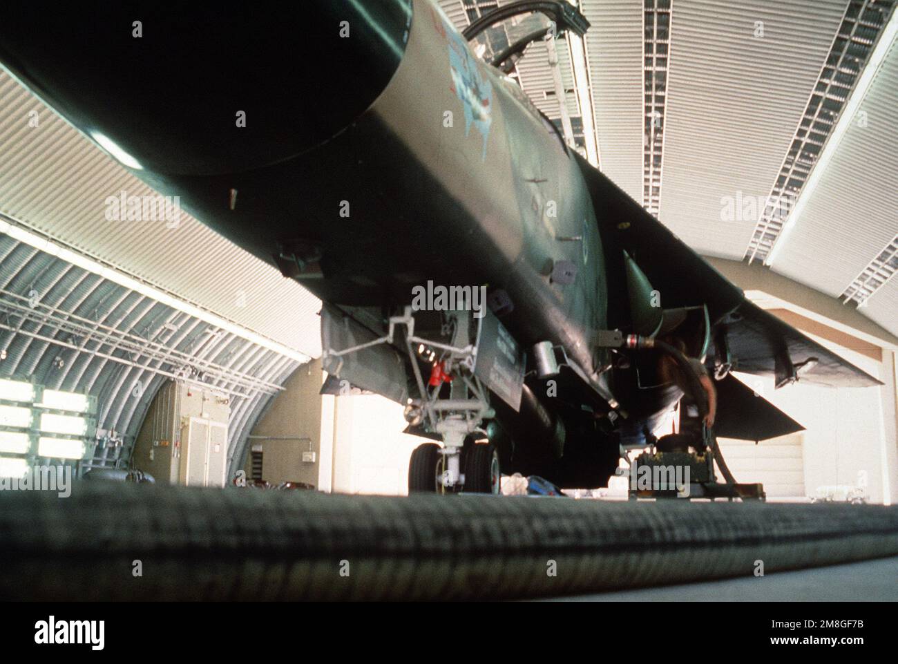 An F-111 aircraft undergoes refueling in a hangar during Operation ...