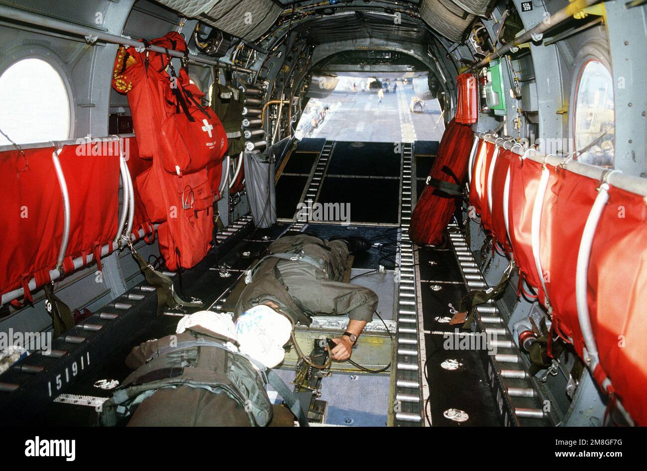 Crew members strapped to the deck of a CH-46 Sea Knight helicopter ...