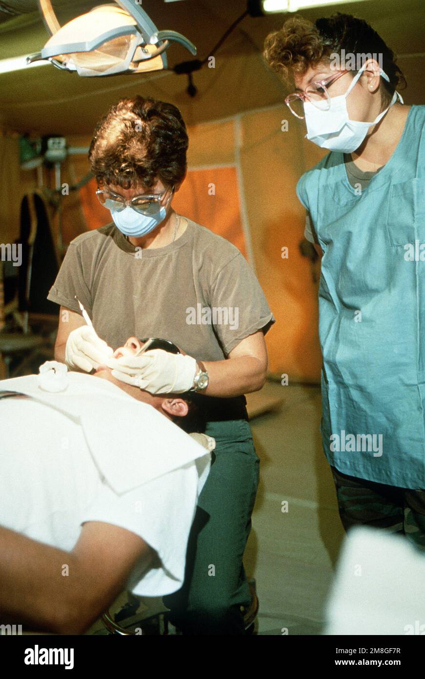 TECH. SGT. Juanita Ferrebee, dental technician, works on a patient as ...