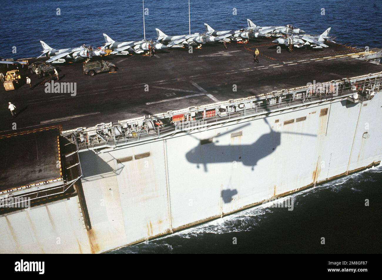The shadow of a CH-46 Sea Knight helicopter moves across the port side ...