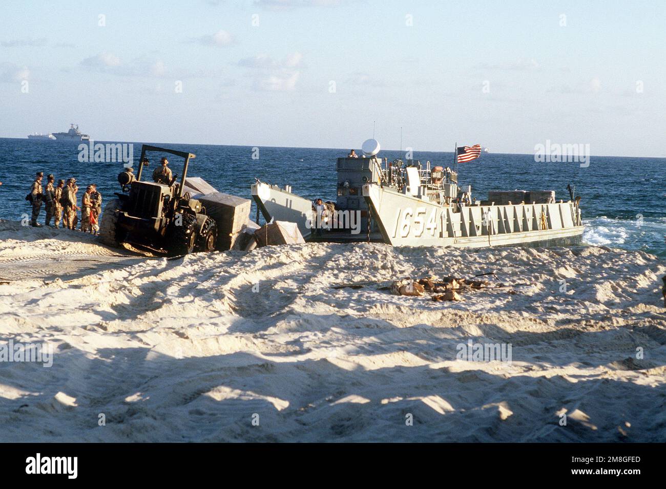 A rough terrain fork lift truck unloads supplies from utility landing ...