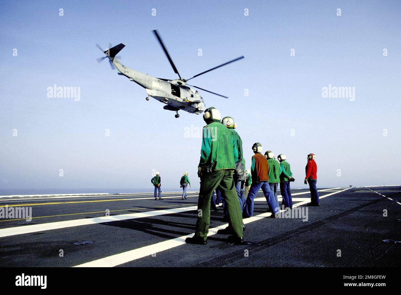 Flight deck crew members stand by as a Helicopter Anti-submarine ...