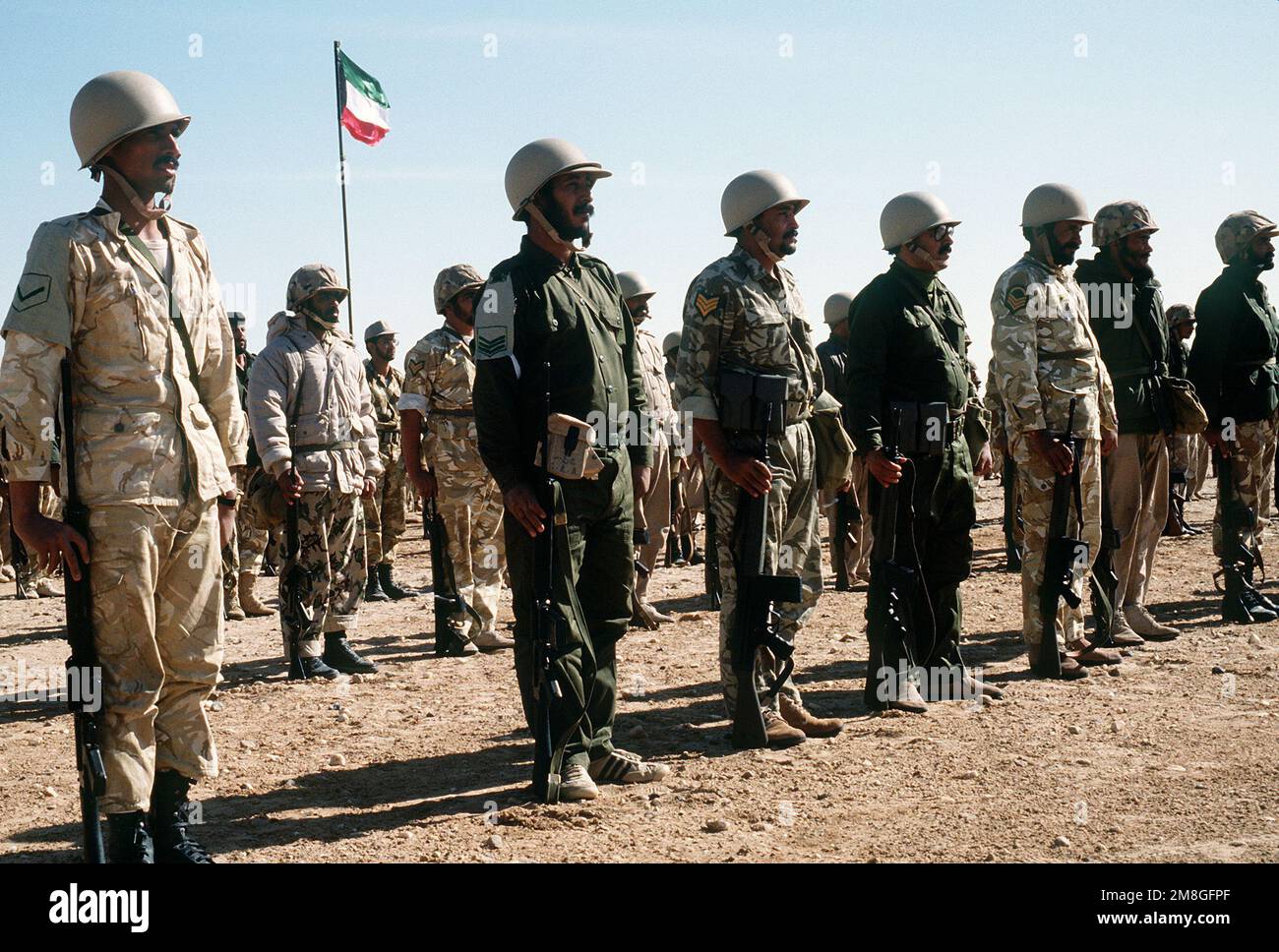 Kuwaiti soldiers stand in formation as a dignitary visits their outpost ...