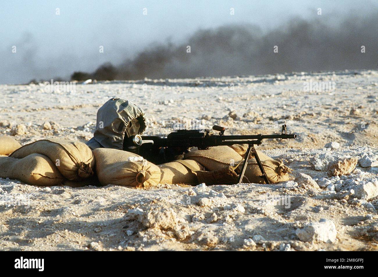 A Syrian soldier aims a 7.62mm PKM light machine gun from his position ...