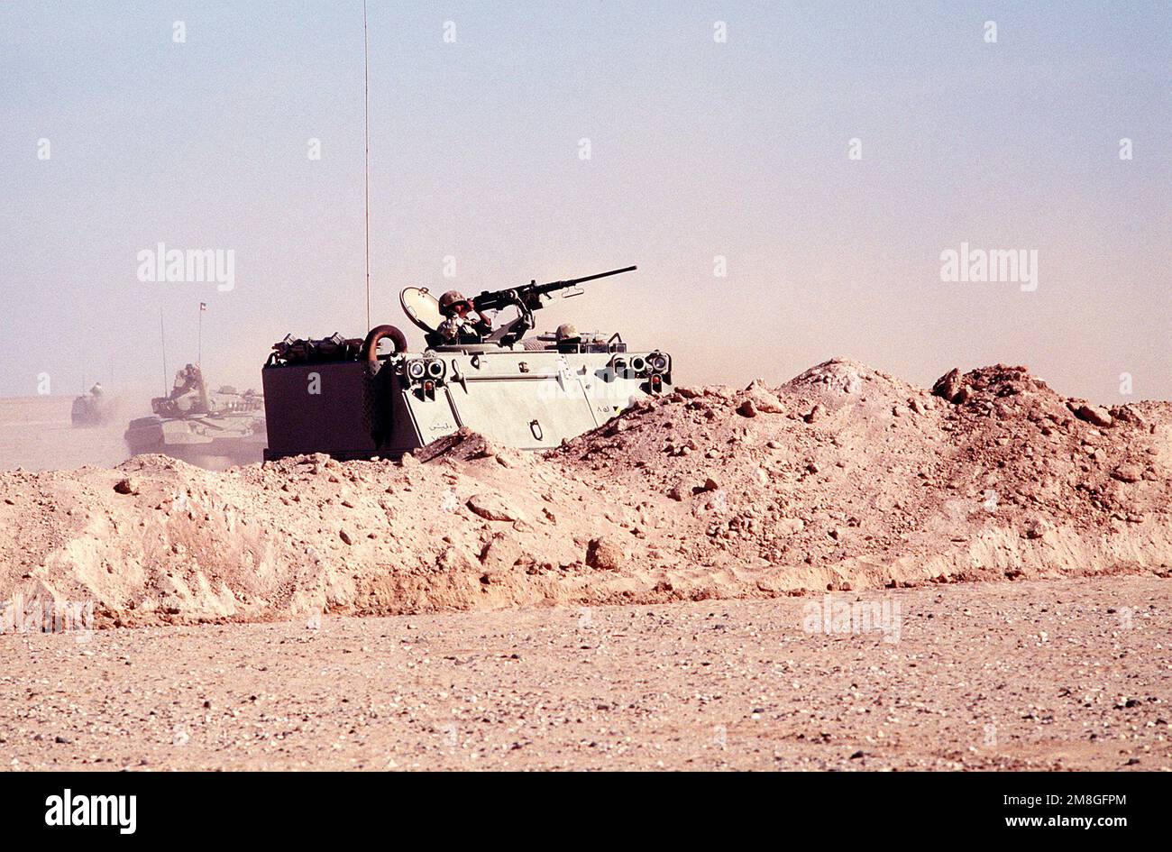 A Kuwaiti soldier mans an M-2 .50-caliber machine gun atop an M-113 ...