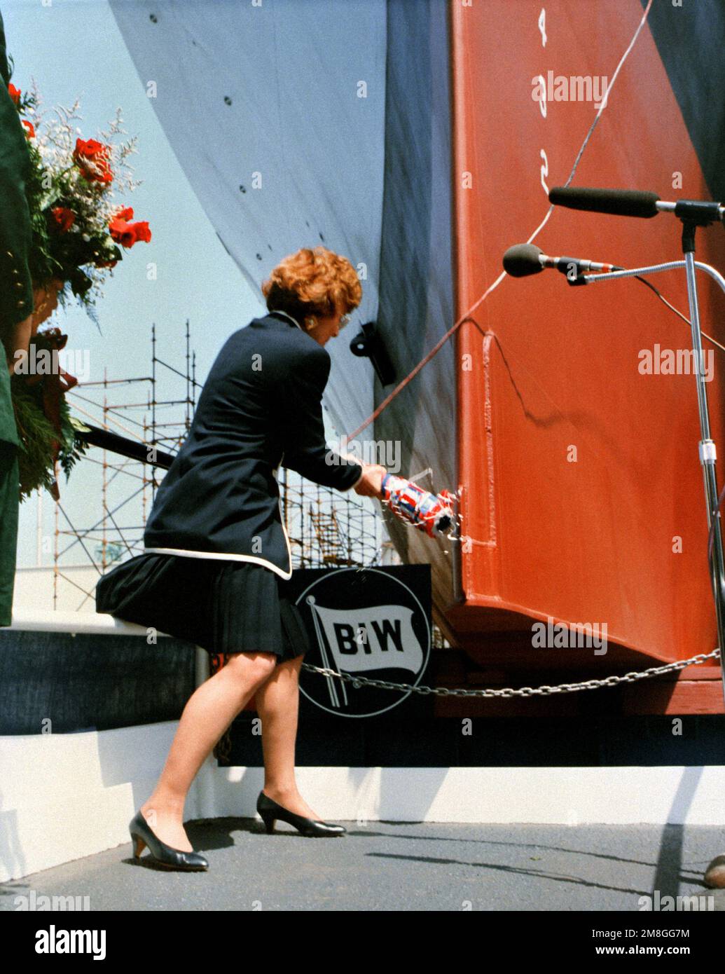 Mrs. Margon Edney, ship's sponsor, christens the guided missile ...