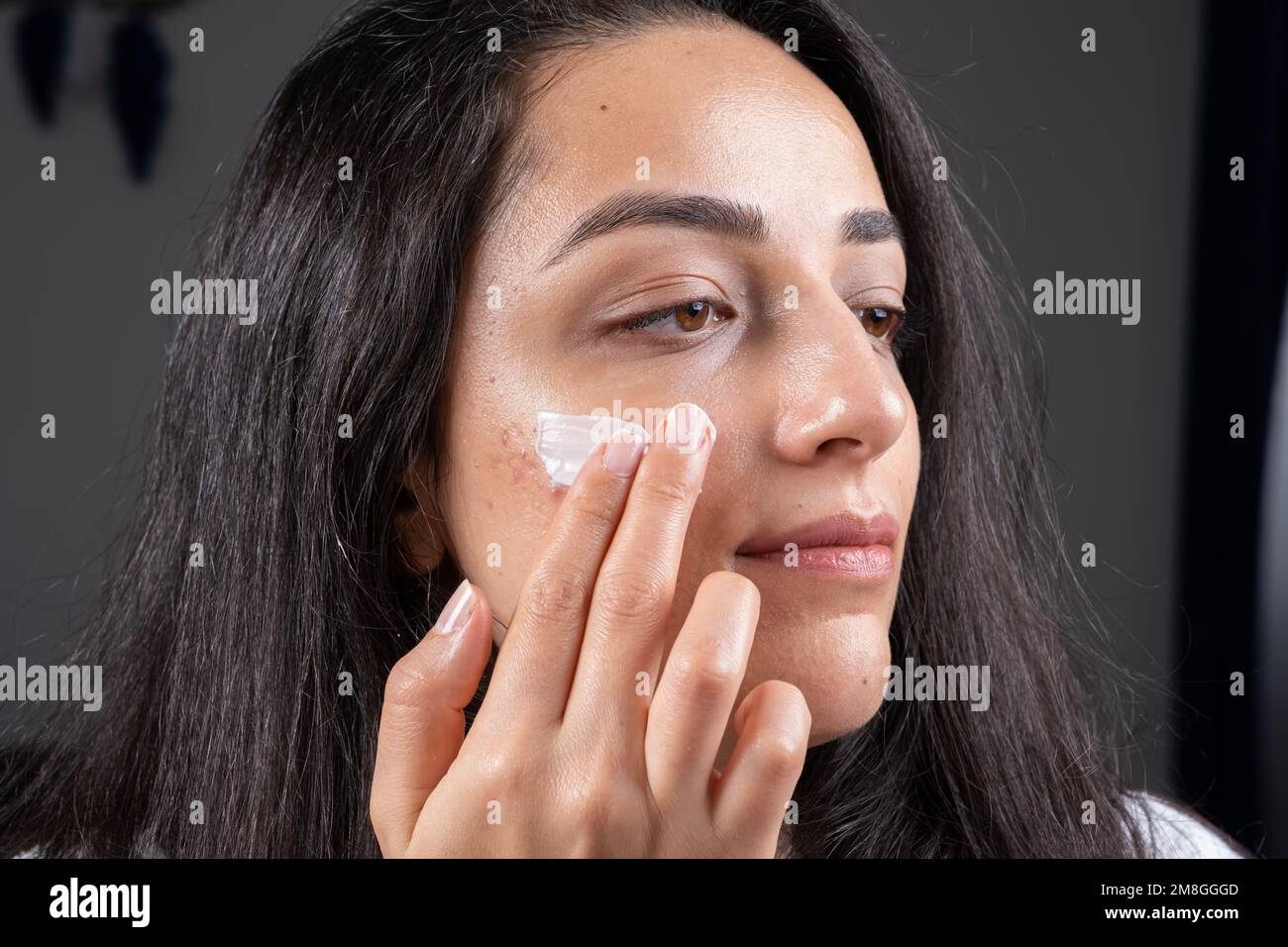 Beautiful Brunette Woman Applying Moisturizing Creme Close Up Head