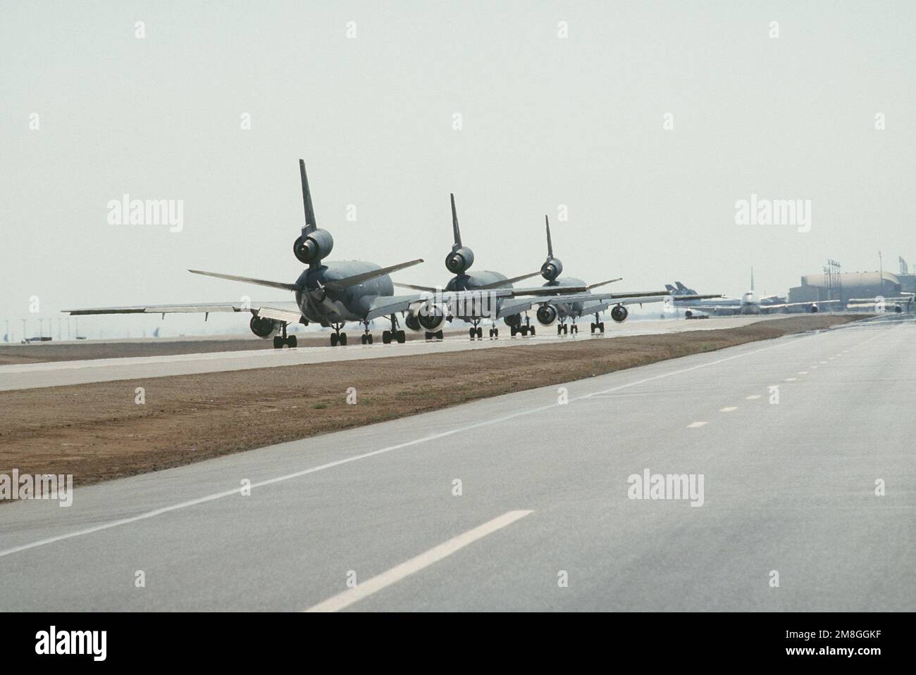 Three KC-10A Extender tanker aircraft taxi down the runway in ...