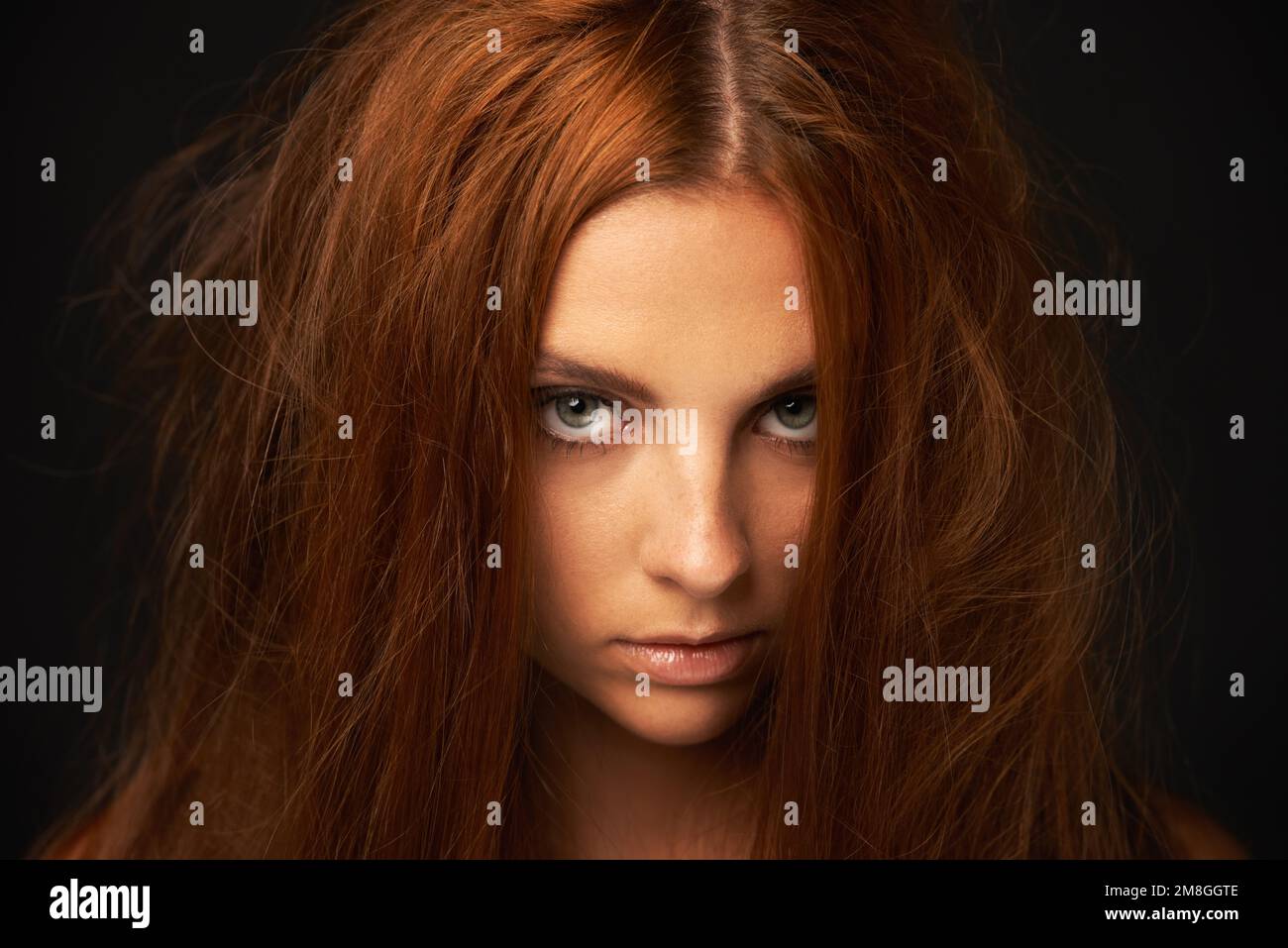 Shes a little intense...Portrait of a pretty redhead with messy hair ...