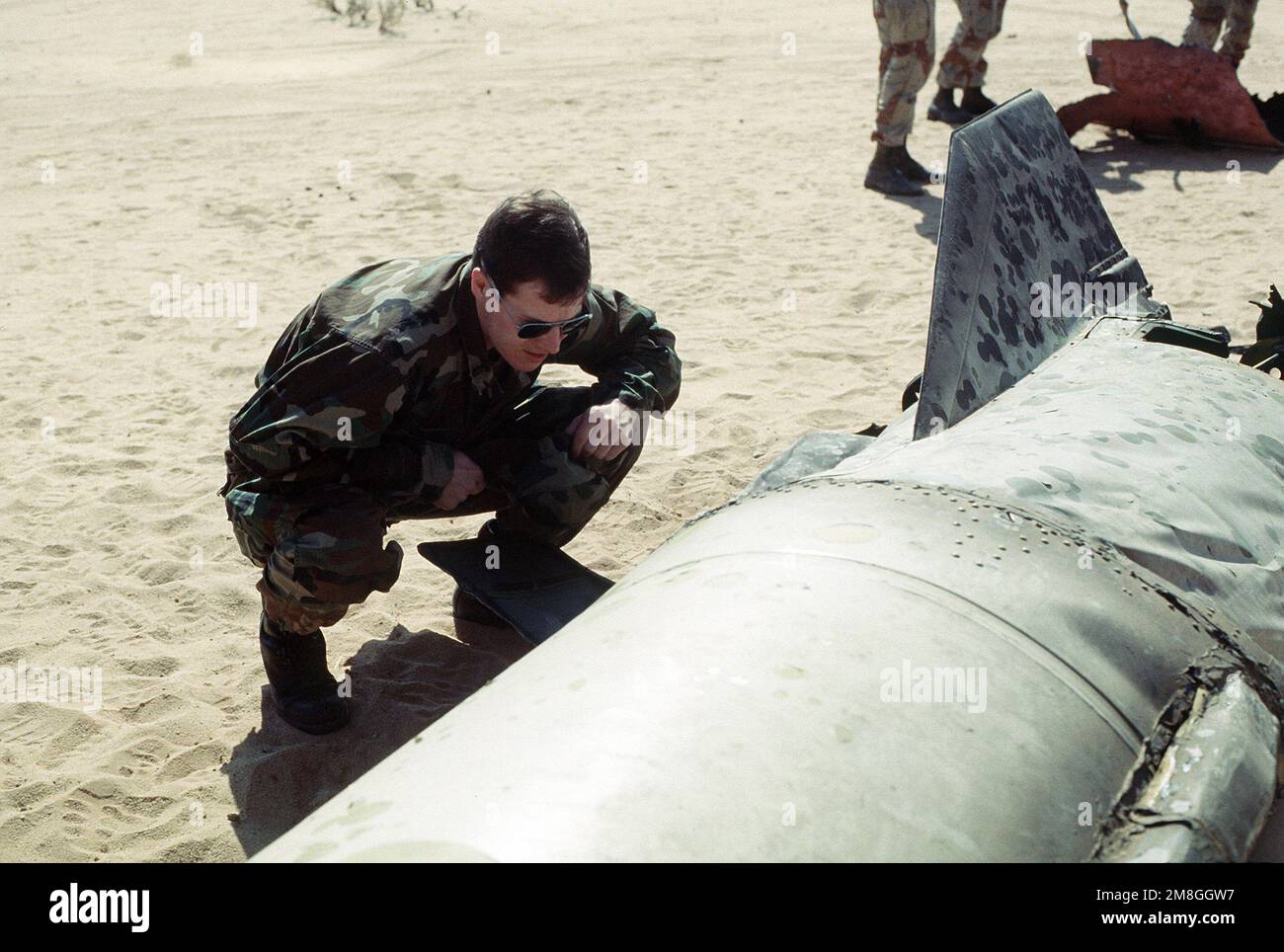 First LT. Jan Copher examines the side of a Scud missile shot down by ...