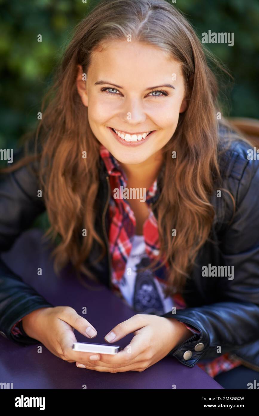 Texting a friend. Portrait of a beautiful teen sending a text message ...
