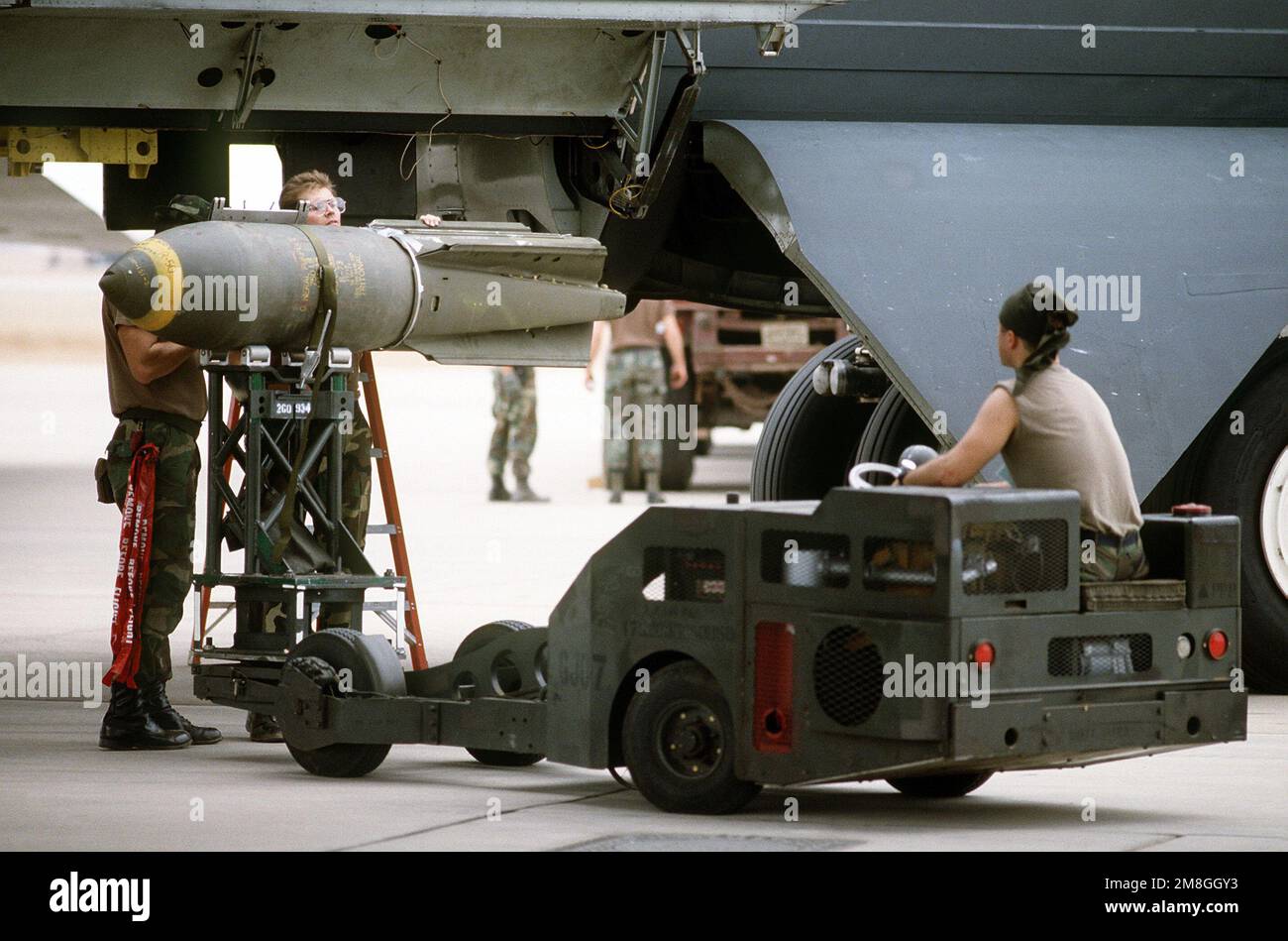 Members of the 1708th Munitions Maintenance Squadron use an MJ-1 bomb loader to load M-117 750 ...