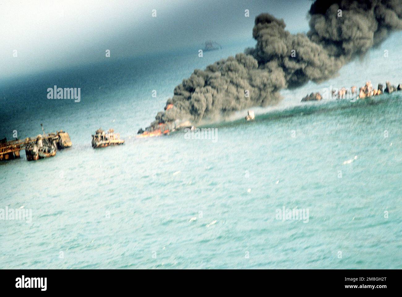 Black smoke pours from burning oil at an offshore oil terminal near ...