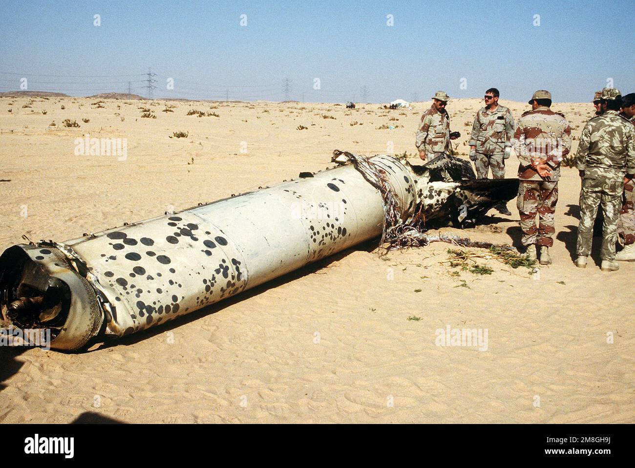 Military personnel examine the tail section of a Scud missile shot down ...