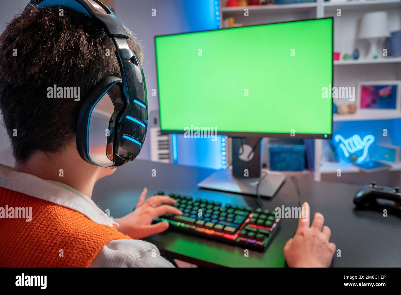 Unrecognizable gamer streaming video games with green screen mock-up ...