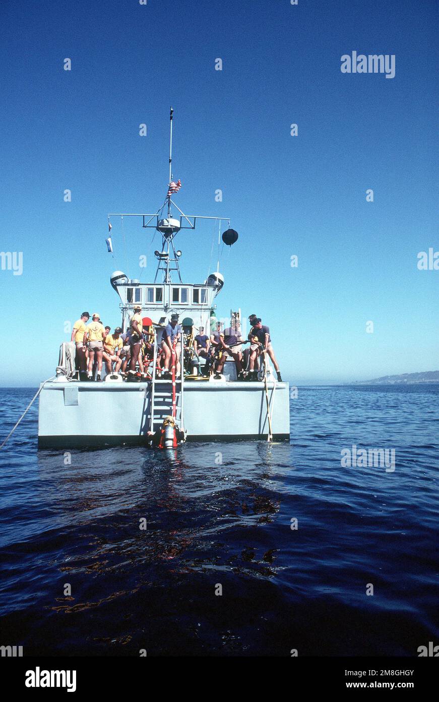 A student diver in the second class diver course enters the water from ...