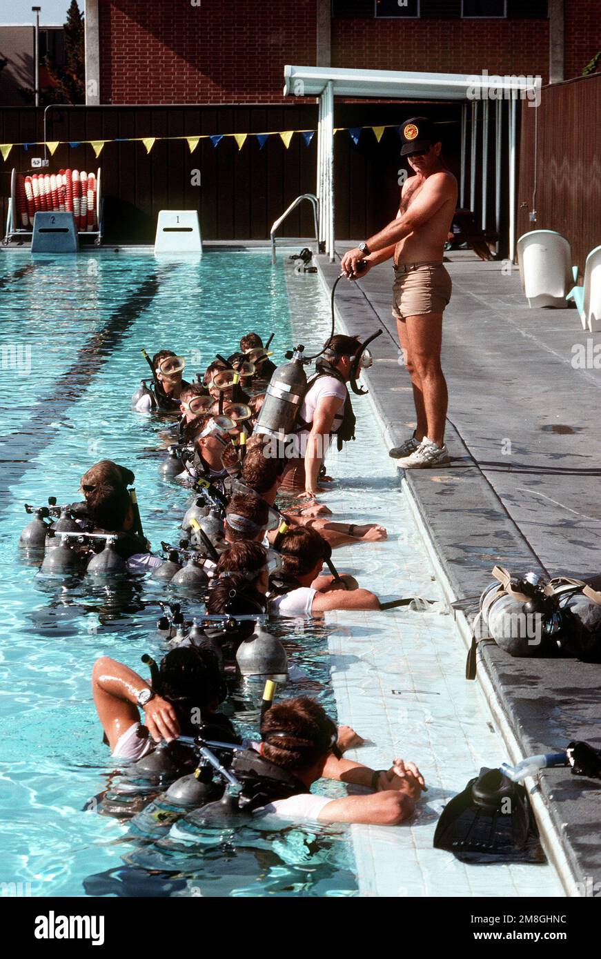 Students in a second class diver course watch as an instructor explains ...