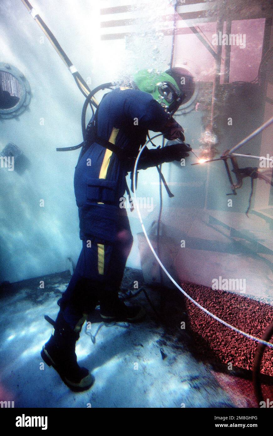 A student in a second class diver course uses a torch in an underwater ...