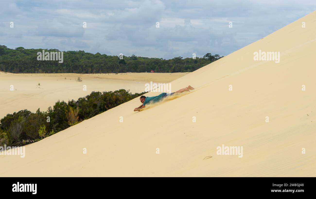 Moreton Island, Queensland, Australia - Man sandboarding down the hill ...