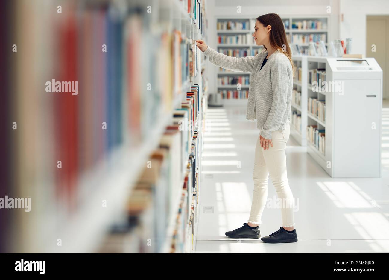 Woman, student and research in library for books, knowledge or learning ...
