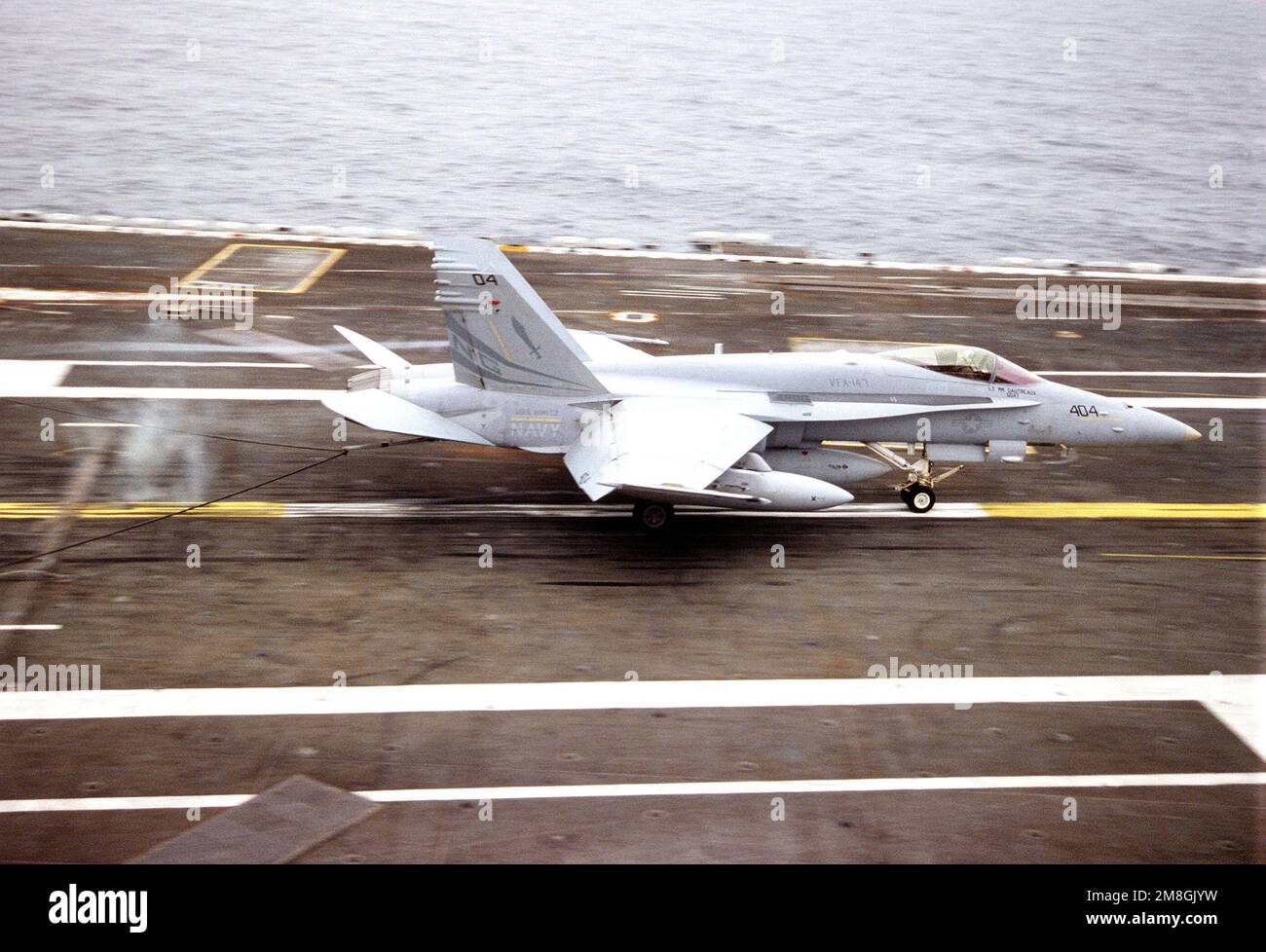A Strike Fighter Squadron 147 (VFA-147) F/A-18C Hornet aircraft lands after catching the ...